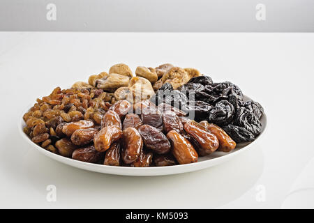 dates plums figs raisins round dish 5 white background Stock Photo - Alamy