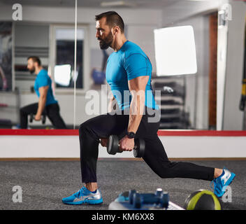 Fitness trainer executing lunges with dumbbells Stock Photo - Alamy
