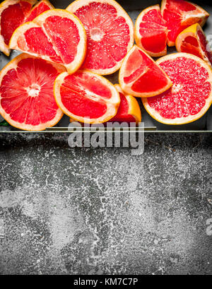 Pieces of fresh grapefruit in the box. On rustic background Stock Photo ...