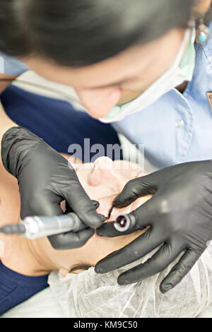 Permanent makeup of the eyebrows, the fingers of the master stretch the ...