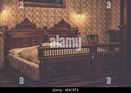Old vintage wooden bedroom in an old house. Visible old bed, wardrobe ...