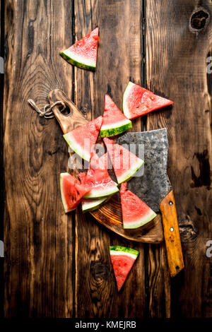 Sliced watermelon with an axe. On wooden background Stock Photo - Alamy