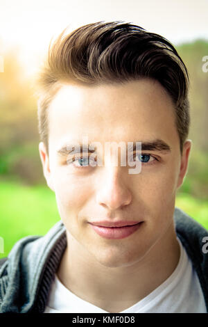 Good looking man with blue eyes and black shirt lying in bed reading ...