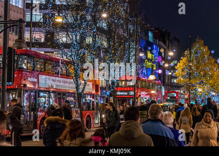 A line of London Buses moving along a busy Oxford St ,crowded with ...