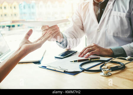 Doctor or physician writing diagnosis and giving a medical prescription ...
