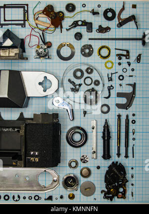 parts are completely disassembled old retro film SLR camera on graph ...