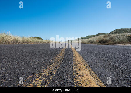 Low Angle of Road with Grasses Over Dunes Stock Photo - Alamy