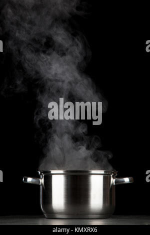 Steaming pot on black background Stock Photo - Alamy