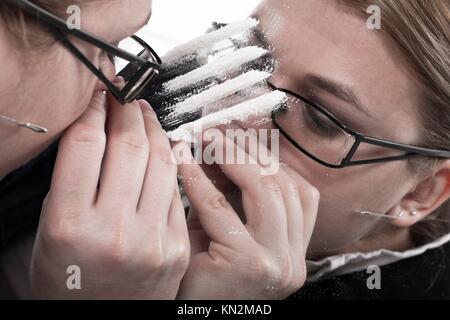 A young woman snorting a line of cocaine off a mirror through a Stock ...