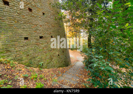 paved path near ancient walls of medieval castle in a green forest ...