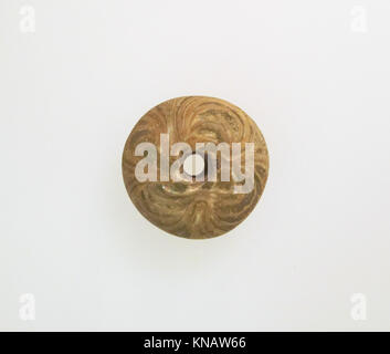 This ancient glass spindle whorl was used for spinning, highlighting ...