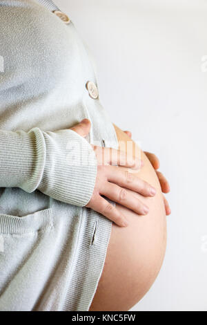 Pregnant woman's cute belly with big red ribbon Stock Photo - Alamy