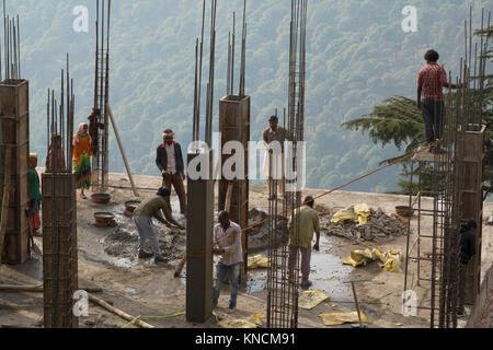 Indian construction workers, male and female, work on the foundation of ...