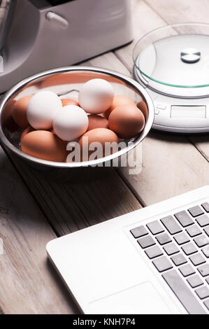 Eggs scale and laptop. On line recipe concept Stock Photo - Alamy