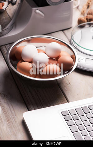 Eggs scale and laptop. On line recipe concept Stock Photo - Alamy