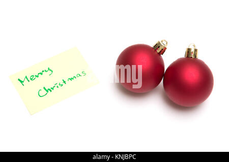 Merry christmas writen on yellow sheet and christmas ball on white ...