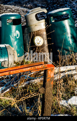 Pile of green garbage bins dumped by the side of an open field. The ...