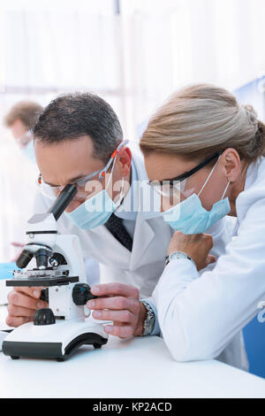 Scientists doing research and analysis with microscope in laboratory ...