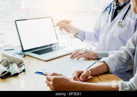 asian female doctor presenting tablet computer screen while seated at ...