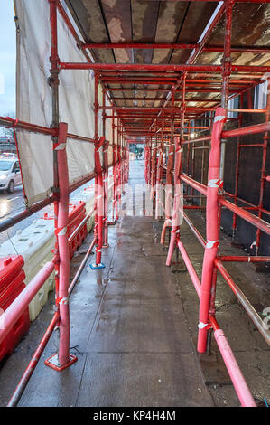 Safe passage for pedestrians made out of red scaffolding on a typical ...