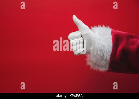 Santa Claus hand against red background Stock Photo - Alamy