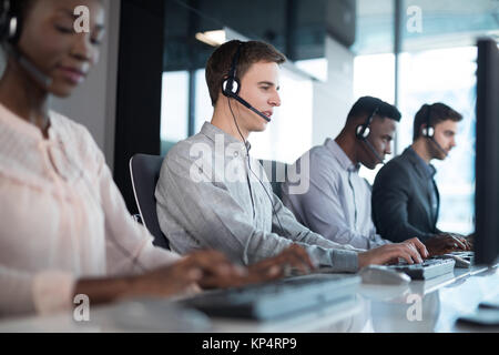 Attentive customer service executives working at office Stock Photo - Alamy