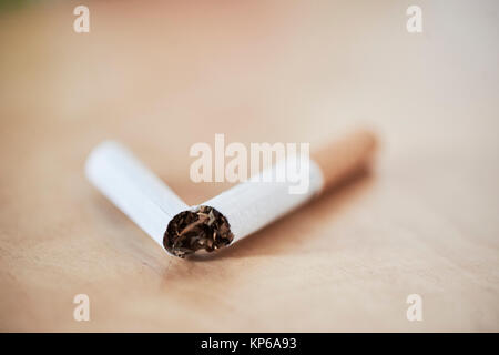 Stop smoking concept - close up of scissors cutting many cigarettes ...