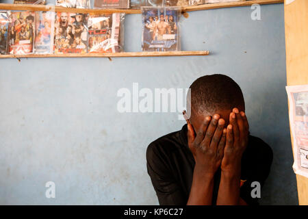 Sad cheerless man hiding face with his hands sitting on chair isolated ...
