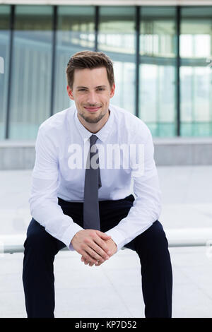 Caucasian businessman sitting on blench at outdoor Stock Photo - Alamy