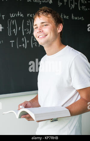 Handsome college student solving a math problem during math class in ...