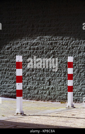Striped red and white signal poles stand on asphalt roadside Stock ...