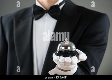 Midsection Of Waiter Holding Ring Bell Stock Photo - Alamy