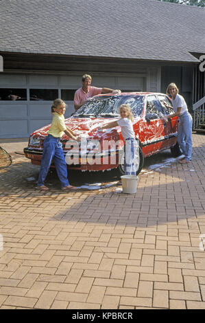 1990 HISTORICAL FAMILY WASHING AUTOMOBILE IN FRONT DRIVEWAY OF SUBURBAN ...
