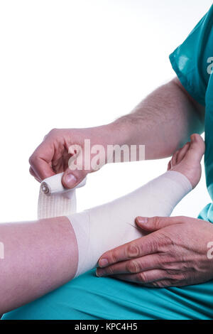 Nurse applying a bandage to a sprained ankle. A sprain is an injury to ...