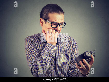 Anxious young business man nervously chewing his tie looking at camera ...