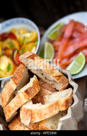 France. Restaurant table with crusty french bread in a basket and white ...