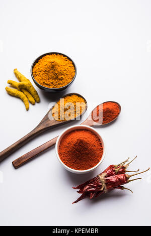 heap of turmeric and red chilli powder in a ceramic bowl on a white or ...