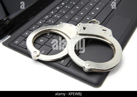 Laptop isolated on white with handcuffs Stock Photo - Alamy