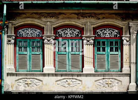 Traditional shop house exterior with green wooden louvered shutters ...
