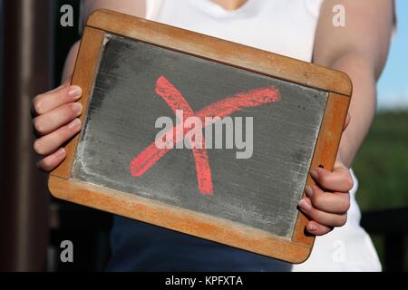 red mistake sign sketched with chalk on slate shown by young female ...