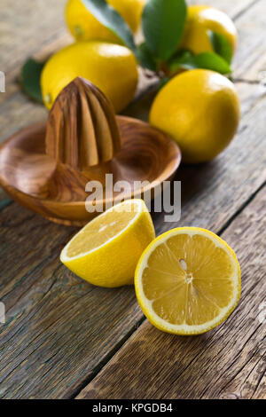 Ripe lemons and squeezer on a old wooden table Stock Photo - Alamy