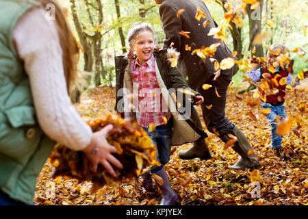 happy family playing with autumn leaves at park Stock Photo - Alamy