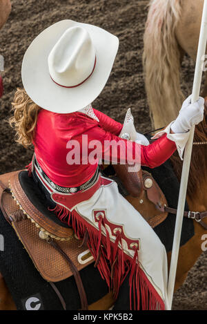 Rodeo cowgirl riding horse carrying American flag during the 4th Annual ...