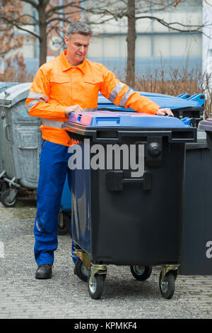 Working Man Holding Dustbin On Street Stock Photo - Alamy