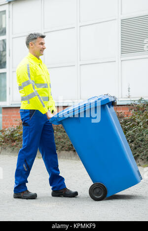 Happy Male Worker Walking With Dustbin On Street During Day Stock Photo ...