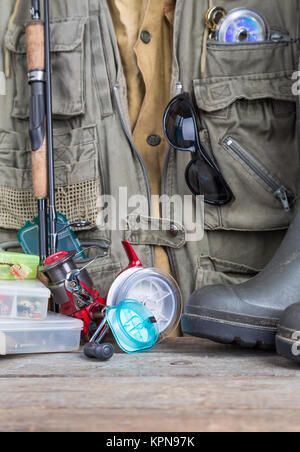 fishing tackles with fishing vest and boots Stock Photo - Alamy