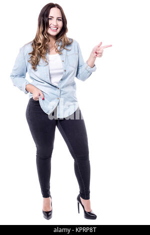 Young woman standing and pointing to the left Stock Photo - Alamy