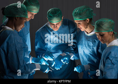 Doctors at work. Diverse group of surgeons working together wearing ...