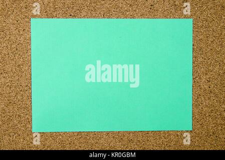 Blank turquoise paper note over cork board background, copy space ...