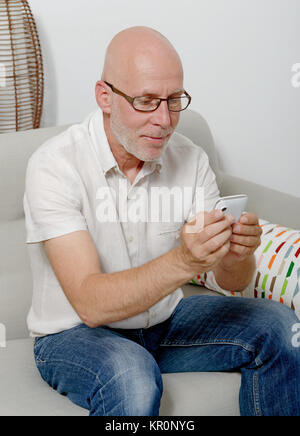Elderly man writes message on smartphone. Concept of using digital ...